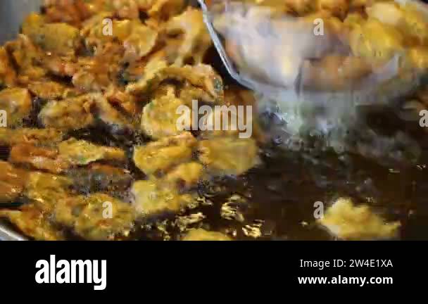 Thai fish cakes called Tod Mun Pla cooking in fresh oil at a local ...