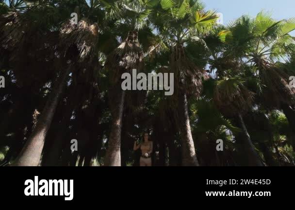 Young athletic beautiful woman in short shorts and top holding machete ...