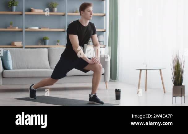 Pilates for men. Young sporty guy practicing stretching training at ...