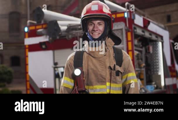 Middle plan of caucasian handsome fireman in helmet and gull equipment ...