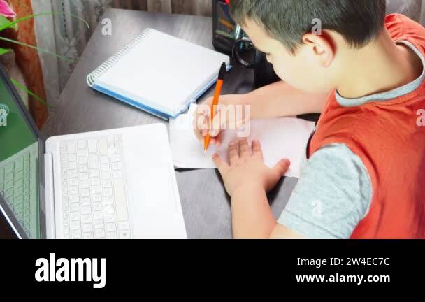 boy studies at home at the computer. remote education, school child ...