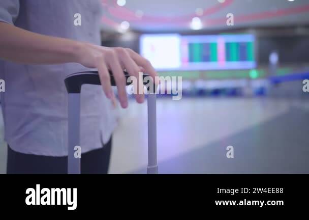 Close up of Young adult female hand drag luggage trolley handle walking ...