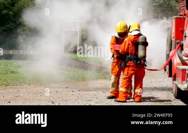 Firefighter fighting with fire flame protection property. Fireman wear ...