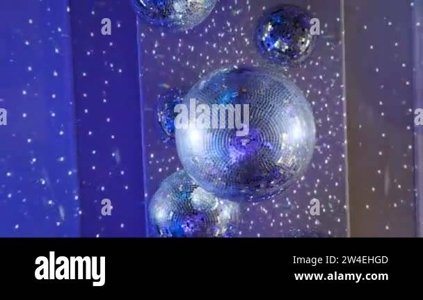 Night disco party concept. Light music disco ball on blue background. Rotating disco ball in ...