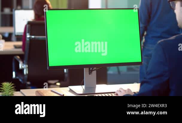 Close up of monitor in office. Green screen. Employee works on computer ...