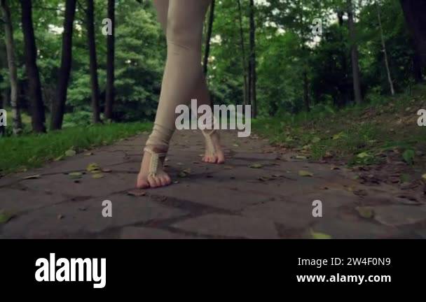 Barefoot female feet walk along the stone path. Around the forest Stock ...