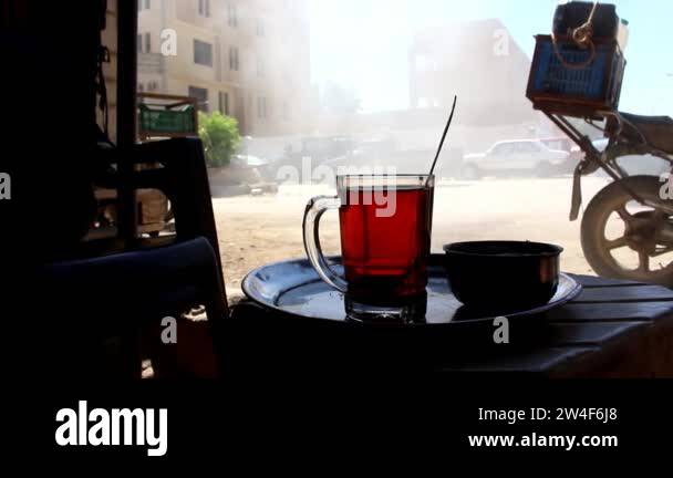 Detail of a bedouin cup of tea with bikes and people in the streets on ...