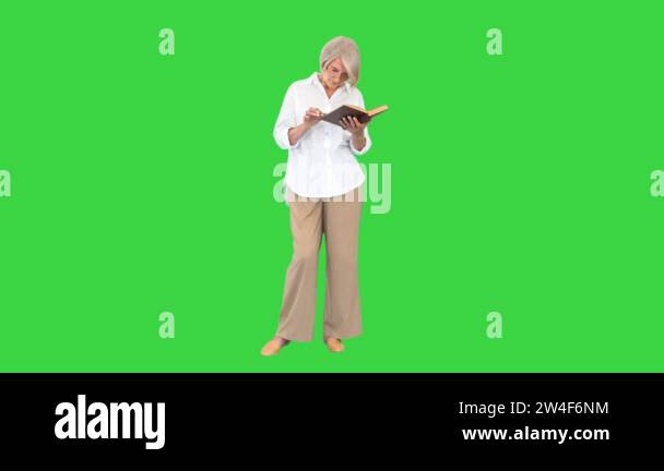 Old lady standing and reading a book on a Green Screen, Chroma Key ...