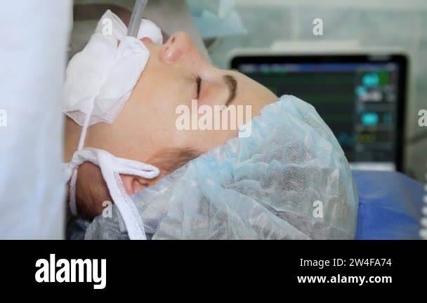 close-up. female patient, in a state of anesthesia, lies on operating ...