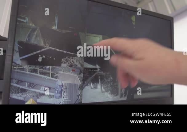 Male Caucasian hand pointing at security cameras on computer screen at ...