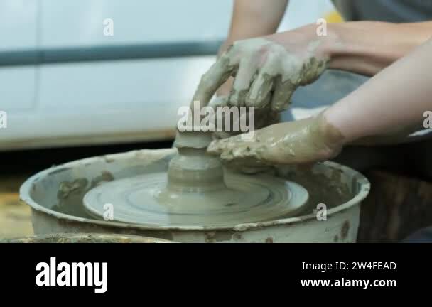 The master Potter teaches the child to make a clay jug on a modern ...