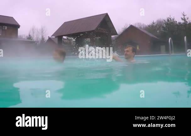 Family having fun in geothermal spa resort. Father and son playing in ...