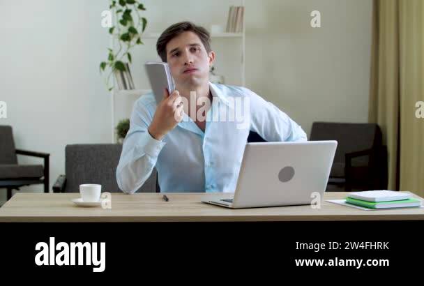 Male worker tired sitting in office without air conditioning ...