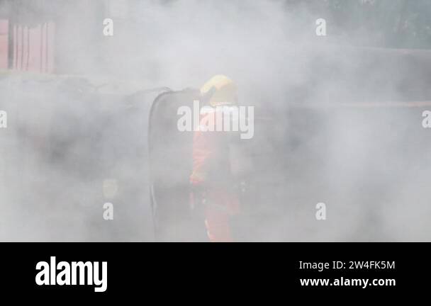 Firefighter fighting with fire flame protection property. Fireman wear ...