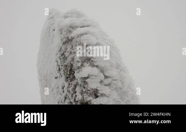 Snow layers accumulating on rock in hard stormy cold weather in winter ...