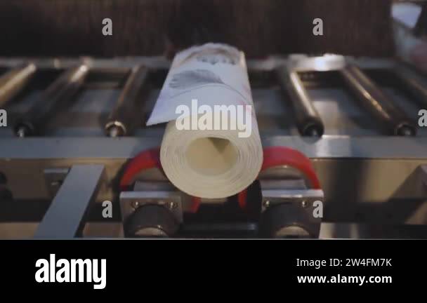 Roll of wallpaper. Conveyor line at wallpaper factory. A roll of ...