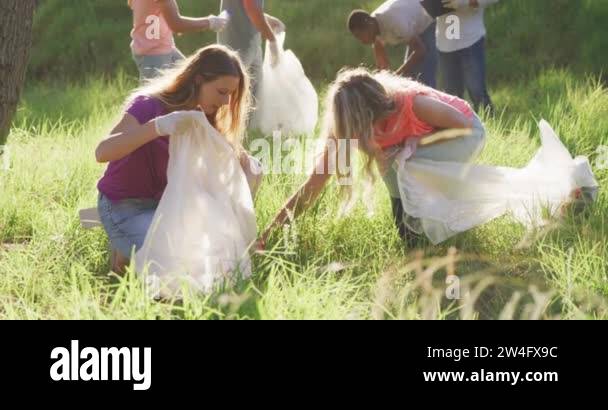 Two Caucasian happy women and a group of volunteers cleaning up a river ...