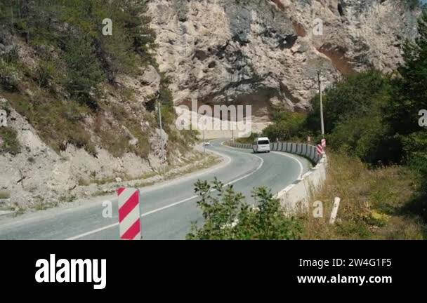 Curvy road with traffic signs in mountains. Red diagonal keep left ...