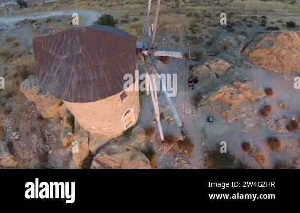 Old traditional historic windmill by the sea at the sunset.Wind power ...