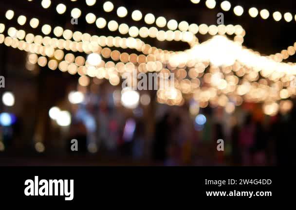 Glittering blurred bokeh of festival decorative string lights hang and ...
