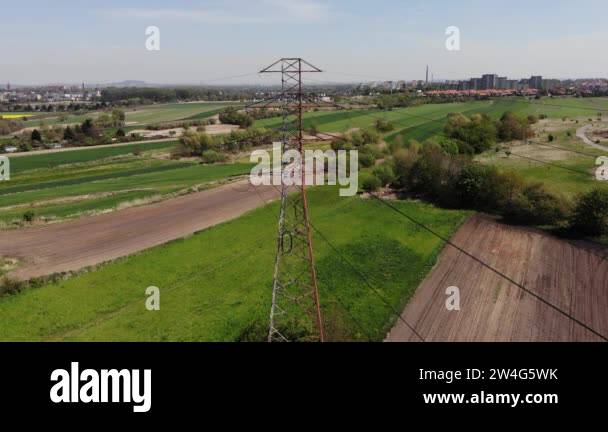 Power pylons and high voltage lines in an agricultural landscape. High ...