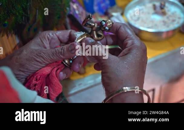 Females Hands Wrapping Figurine Of Lord Krishna During Janmashtami ...