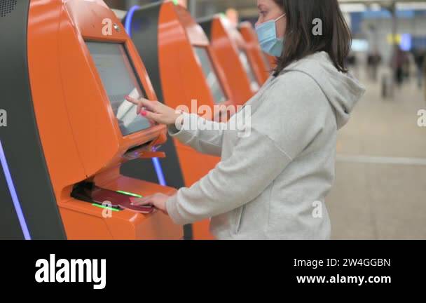 Woman Doing Self-Check In The Airport. woman travel in protective mask ...