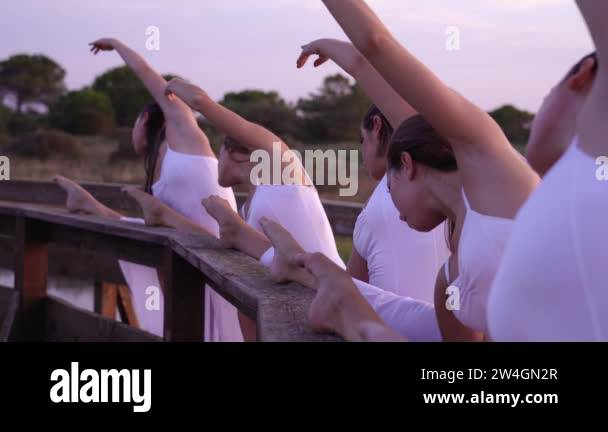 Women stand in ballet poses putting feet on bridge railing Stock Video ...