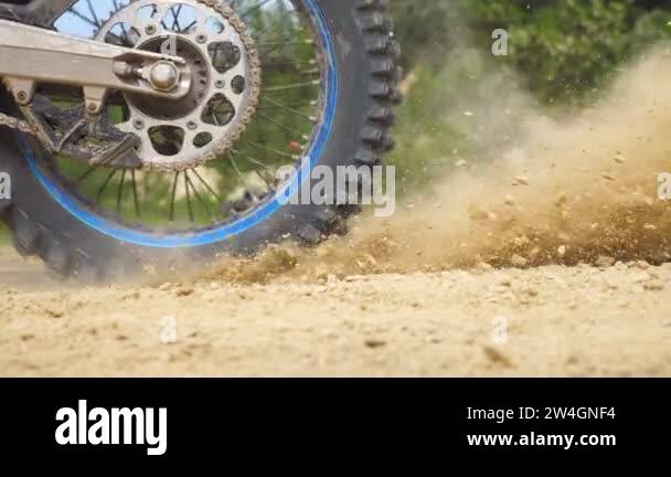 Close up wheel of powerful off-road motorcycle spinning and kicking up ...