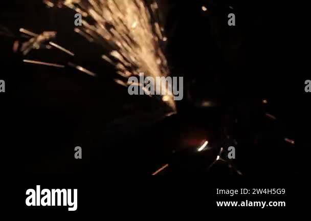 Angle Grinder strike sparks in a dark garage running the wizard for the production of a metal ...