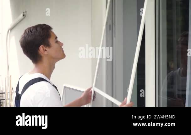 Worker installs new mosquito nets. Workman is installing insect mesh ...