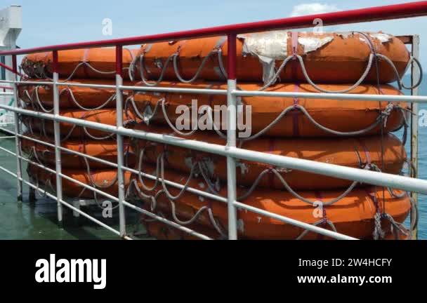 Old orange color small rigid lifeboat or life raft for emergency ...