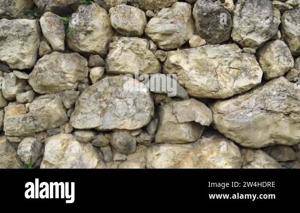 Texture of old stones of various forms with seams. Close up of shabby ...