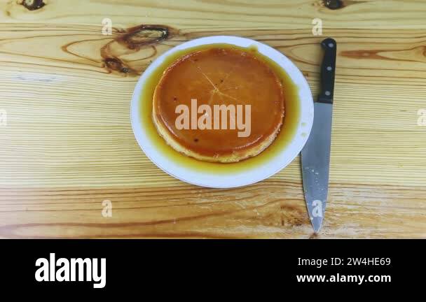 slowly zoom top view at sliced whole round soft milk flan with caramel ...
