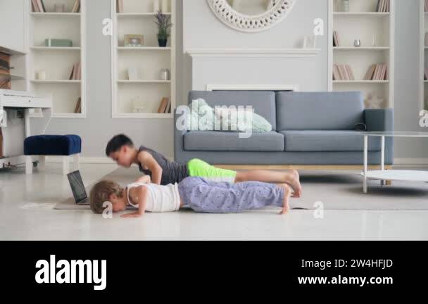 Two caucasian boys doing physical exercise push ups and abs crunches ...