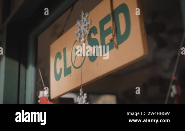 A sign hanging on the door of the institution with a glass window with ...