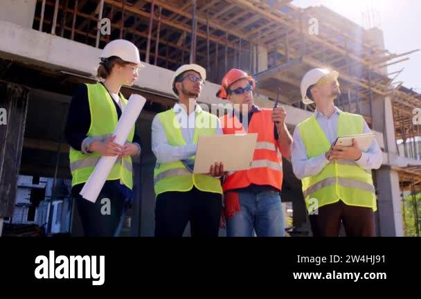 Group of multiracial engineers and architect and with a foreman analyzing form the laptop and ...