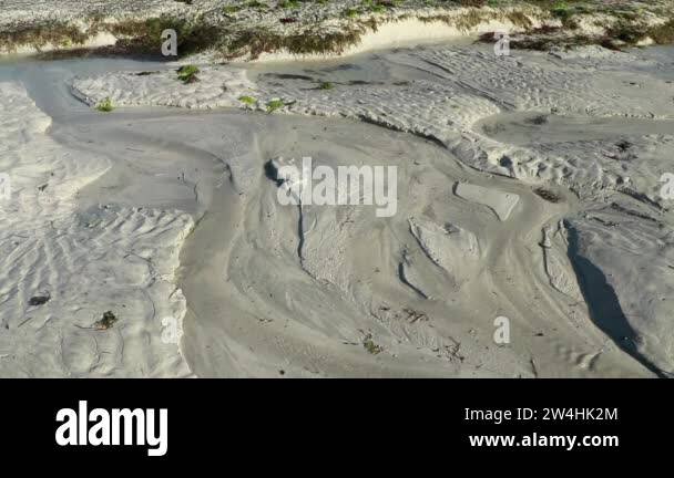 in the sharp foreground of the film picture sand mud holes with water ...