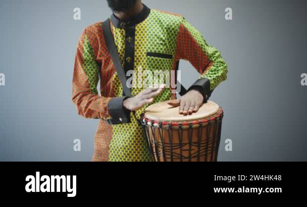 Portrait of male African American musician tapping on drum and smiling ...
