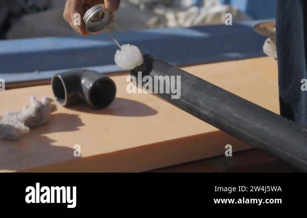 Applying glue to the ends of a plastic pipe. Bonding water pipes ...