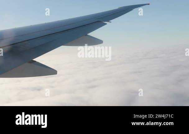 Airplane flight. Wing of an airplane flying above the clouds with ...
