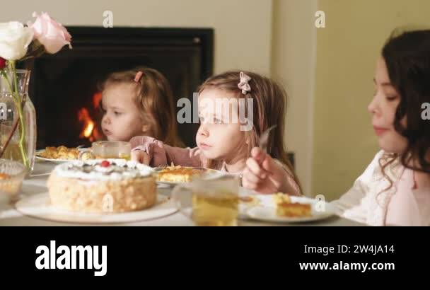 Little girls eat a pie at the table with a fork. Proper nutrition of ...