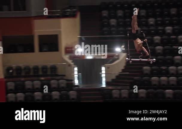 Acrobatic man upside down flying around on construction for performance ...