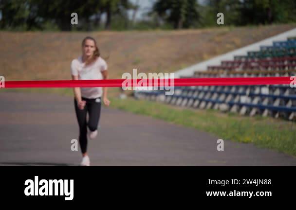 Beautiful Fit Female Runner Crossing the Finish Line on a Professional ...