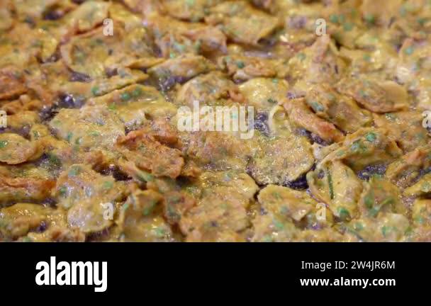 Thai fish cakes called Tod Mun Pla cooking in fresh oil at a local ...