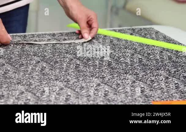 Close up hands of a seamstress make a drawing on the fabric using a ...
