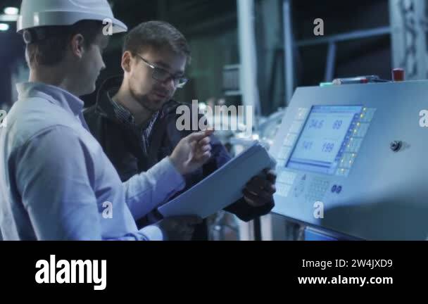 Engineer and Factory Worker are Setting Up CNC Lathe Machine Together Stock Video Footage - Alamy