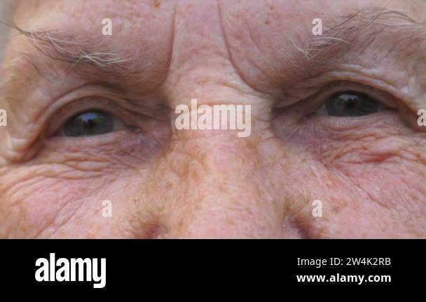 Close Up Gray Eyes Of Elderly Grandmother Stares And Blinks With Happy