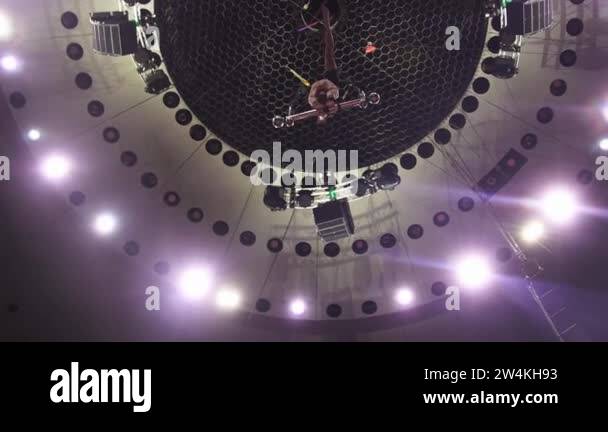 An acrobatic man training his performance on the flying bar at circus ...