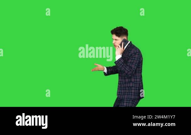 Young angry emotional man in formal suit talking on the phone and ...